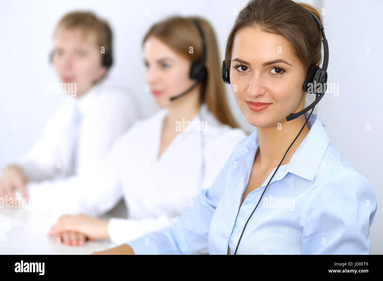 Call center. Focus on beautiful woman in headset Stock Photo - Alamy
