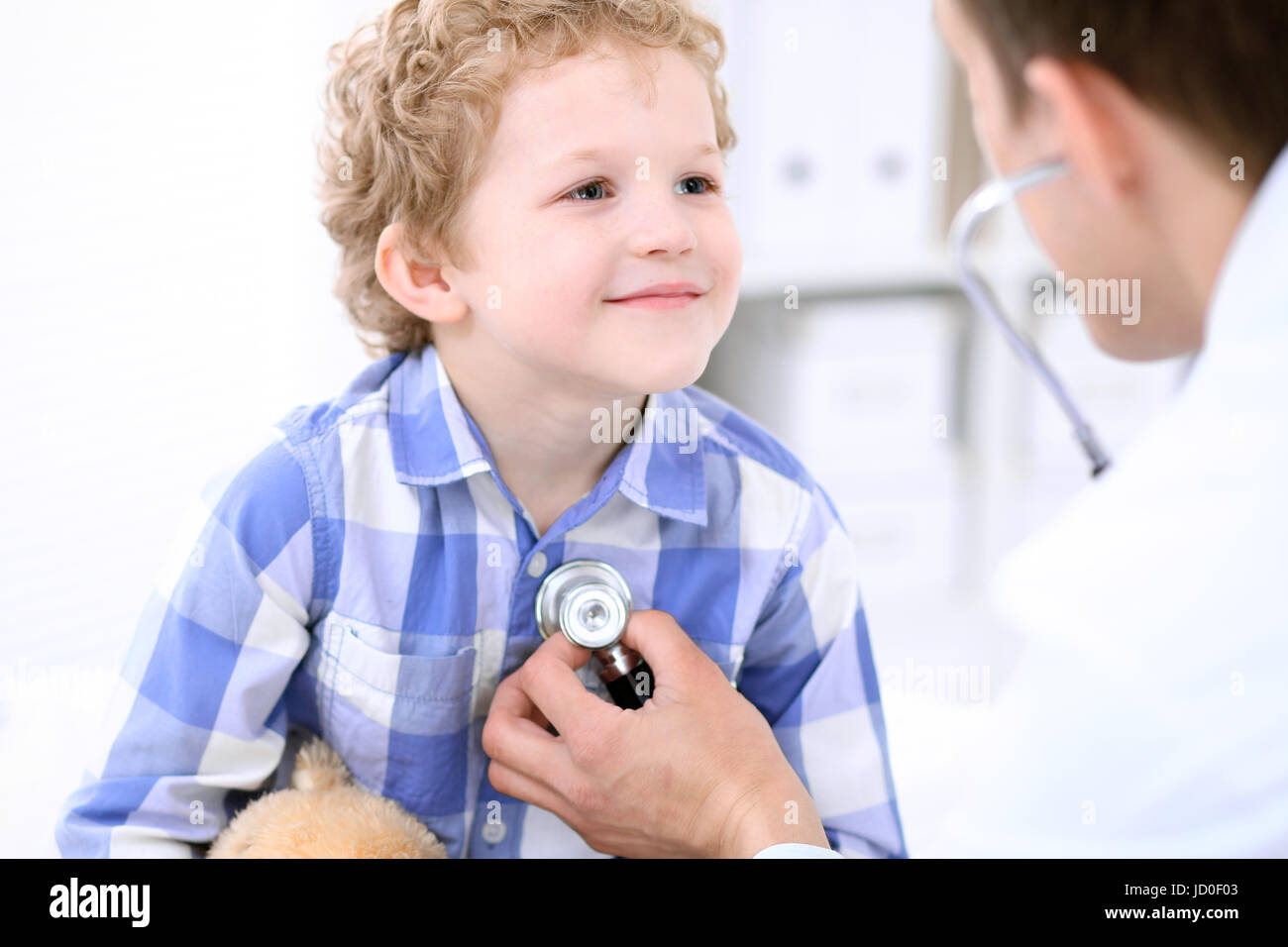 Doctor examining a child patient by stethoscope Stock Photo - Alamy