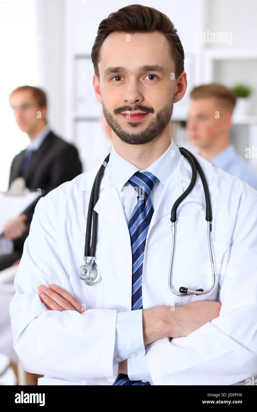 Friendly male doctor on the background doctor and many patients Stock ...