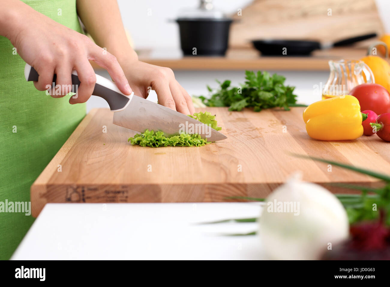 Close up of woman's hands cooking in the kitchen. Housewife slicing ...