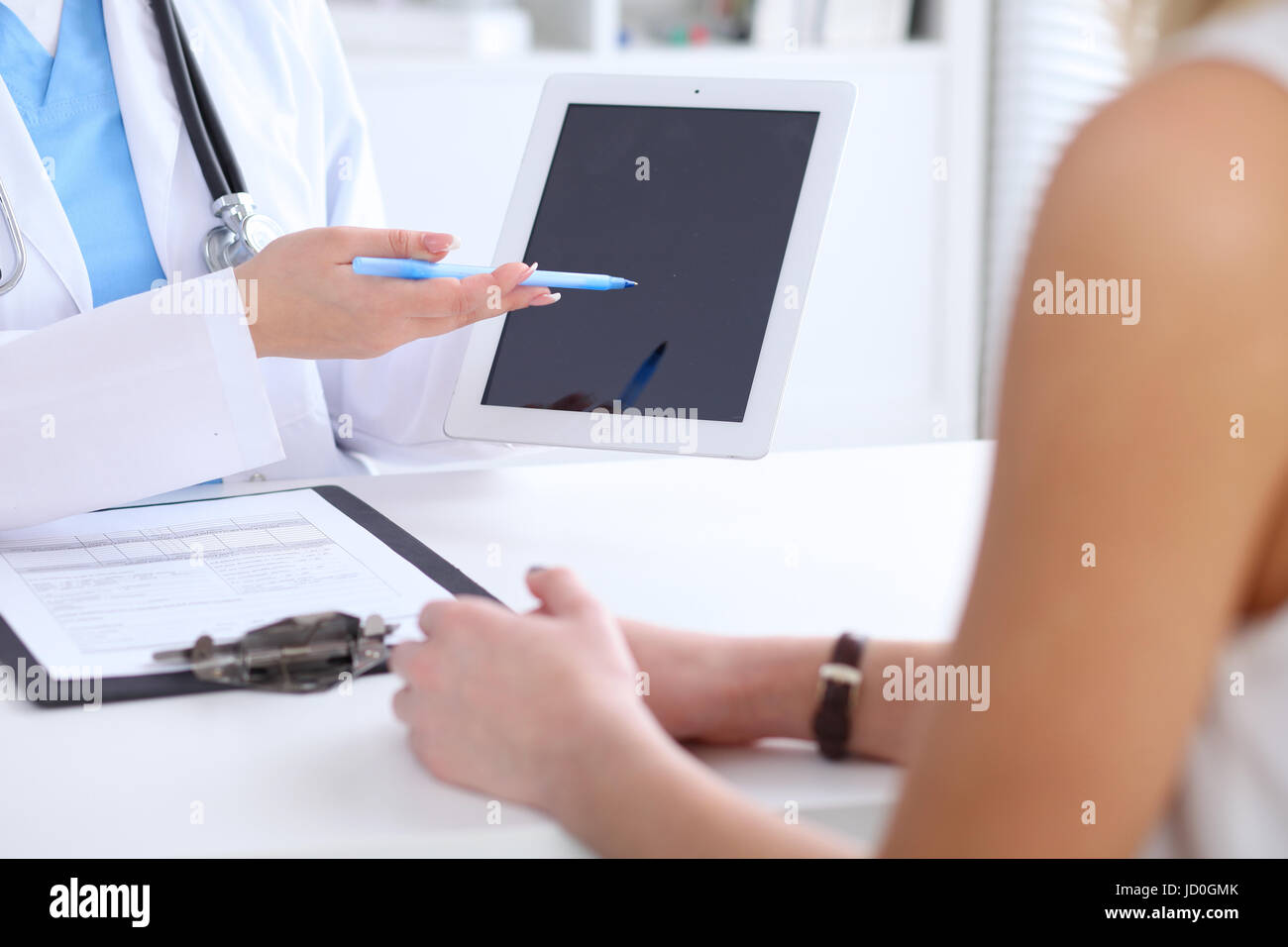 Close up of a doctor and patient hands while phisician pointing into ...