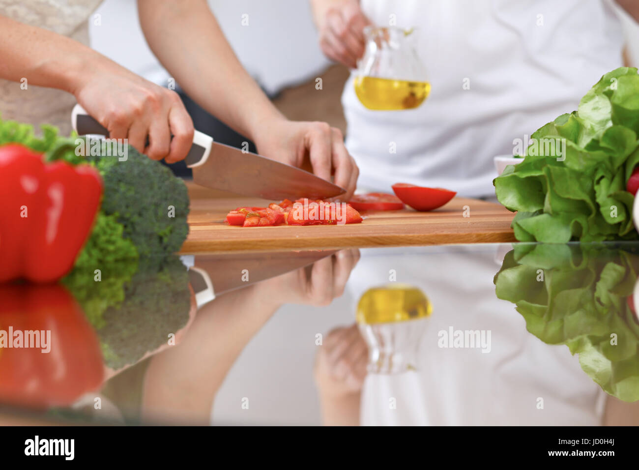 Closeup of two women are cooking in a kitchen. Friends having fun while ...