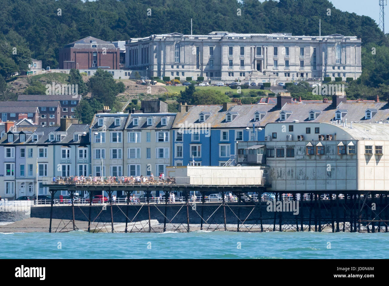 A view of Aberystwyth seafront pier with the National library of Wales ...