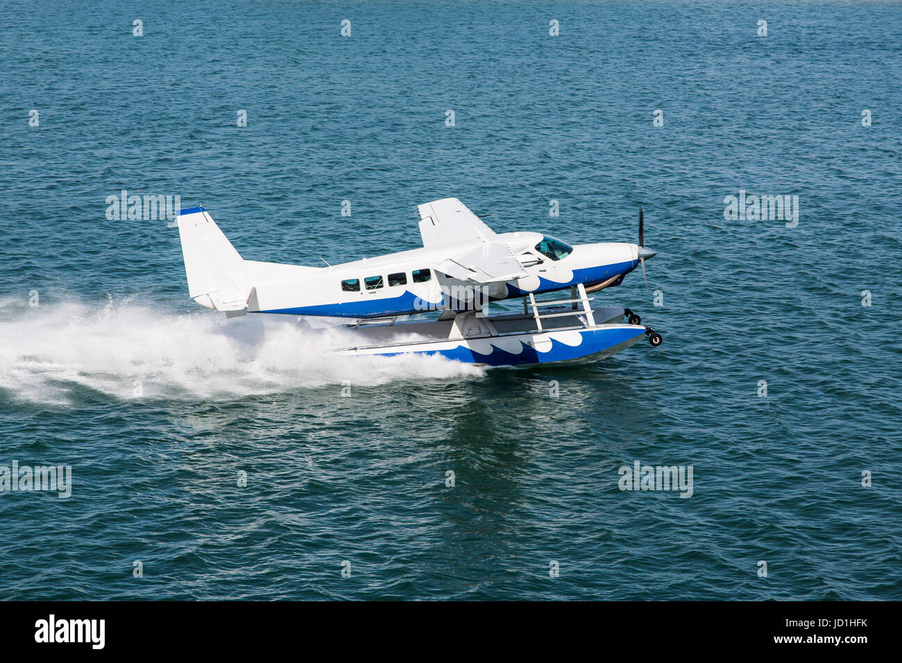 Blue and White Seaplane Taking Off in Aqua Water Stock Photo - Alamy