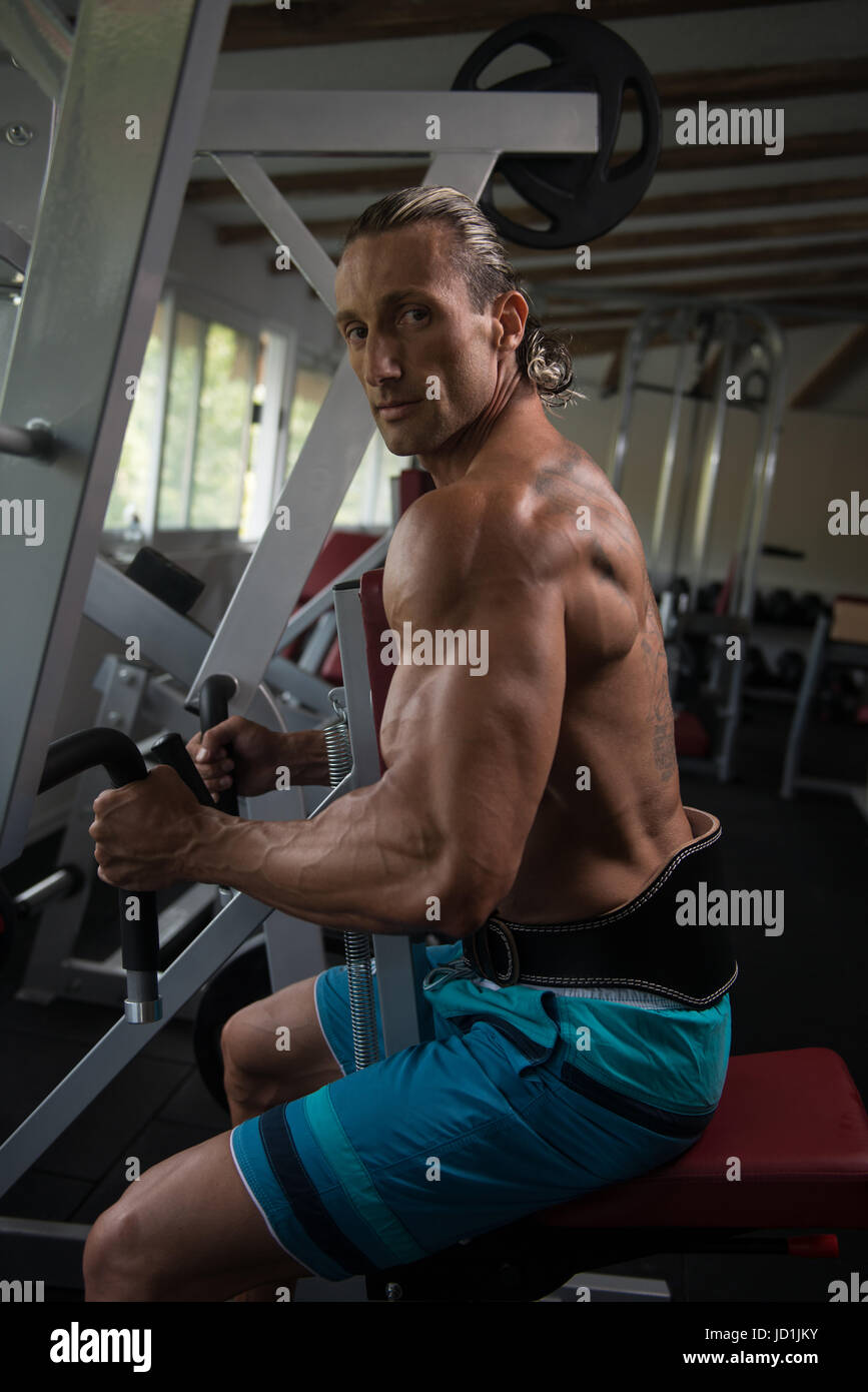Handsome Bodybuilder Doing Heavy Weight Exercise For Back On Machine ...
