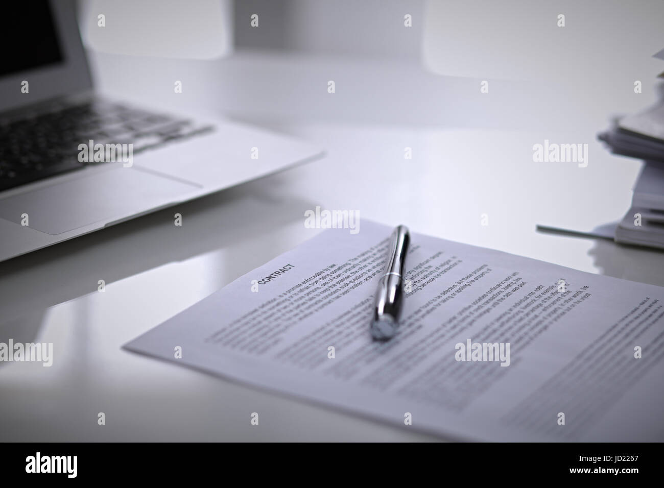 Office workplace with a laptop and contract document on the light ...