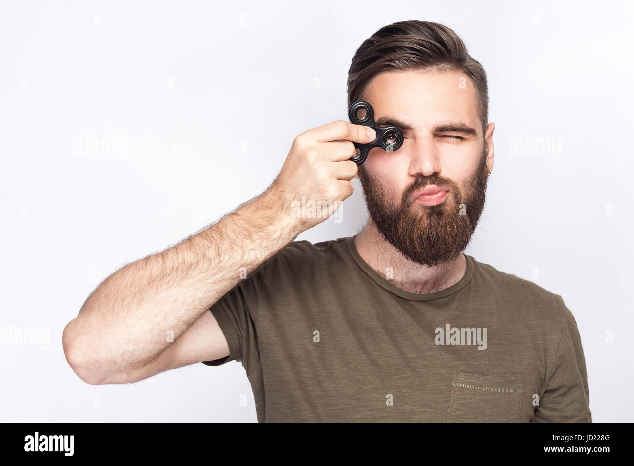 Young man holding and playing with fidget spinner. studio shot on white ...