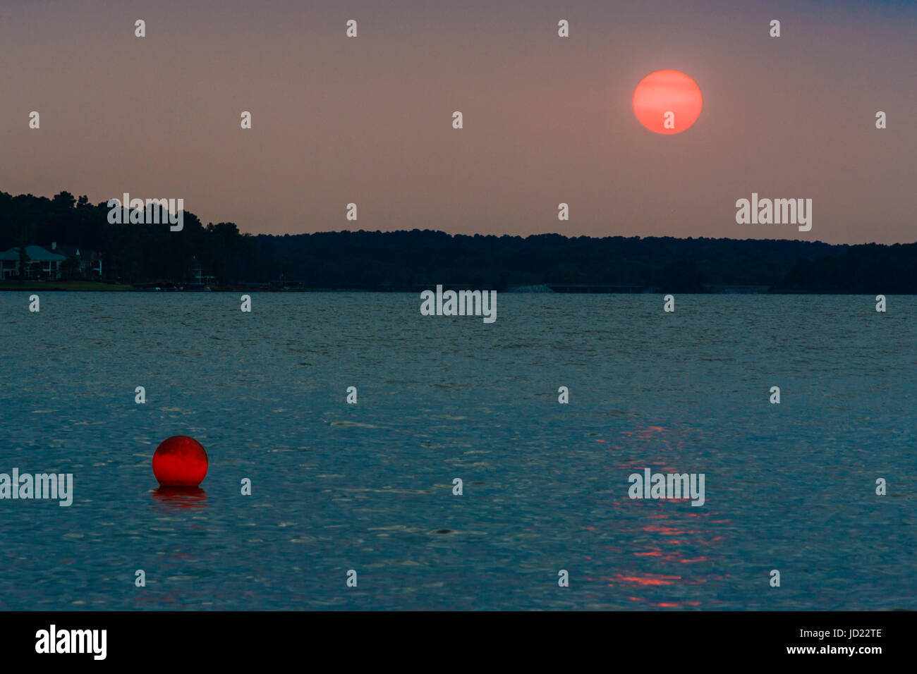 Red ball contrasting with twilight blue and pink glow at sunset on Lake ...