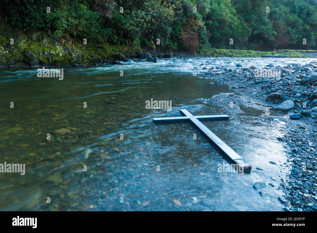 White cross floating in a stony river Stock Photo - Alamy