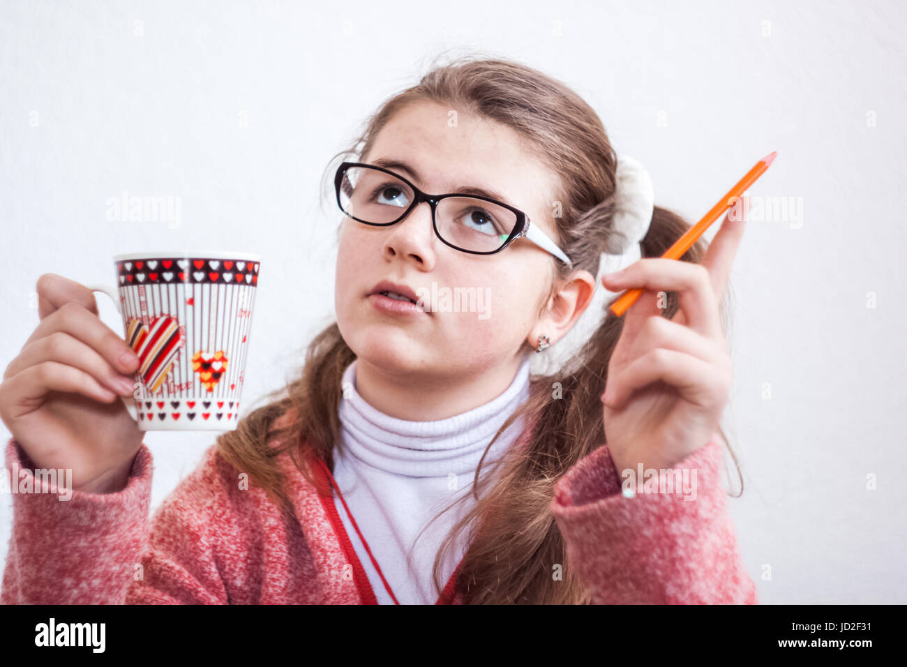 Beautiful cute little blonde girl looks thoughtfully and concentrated ...