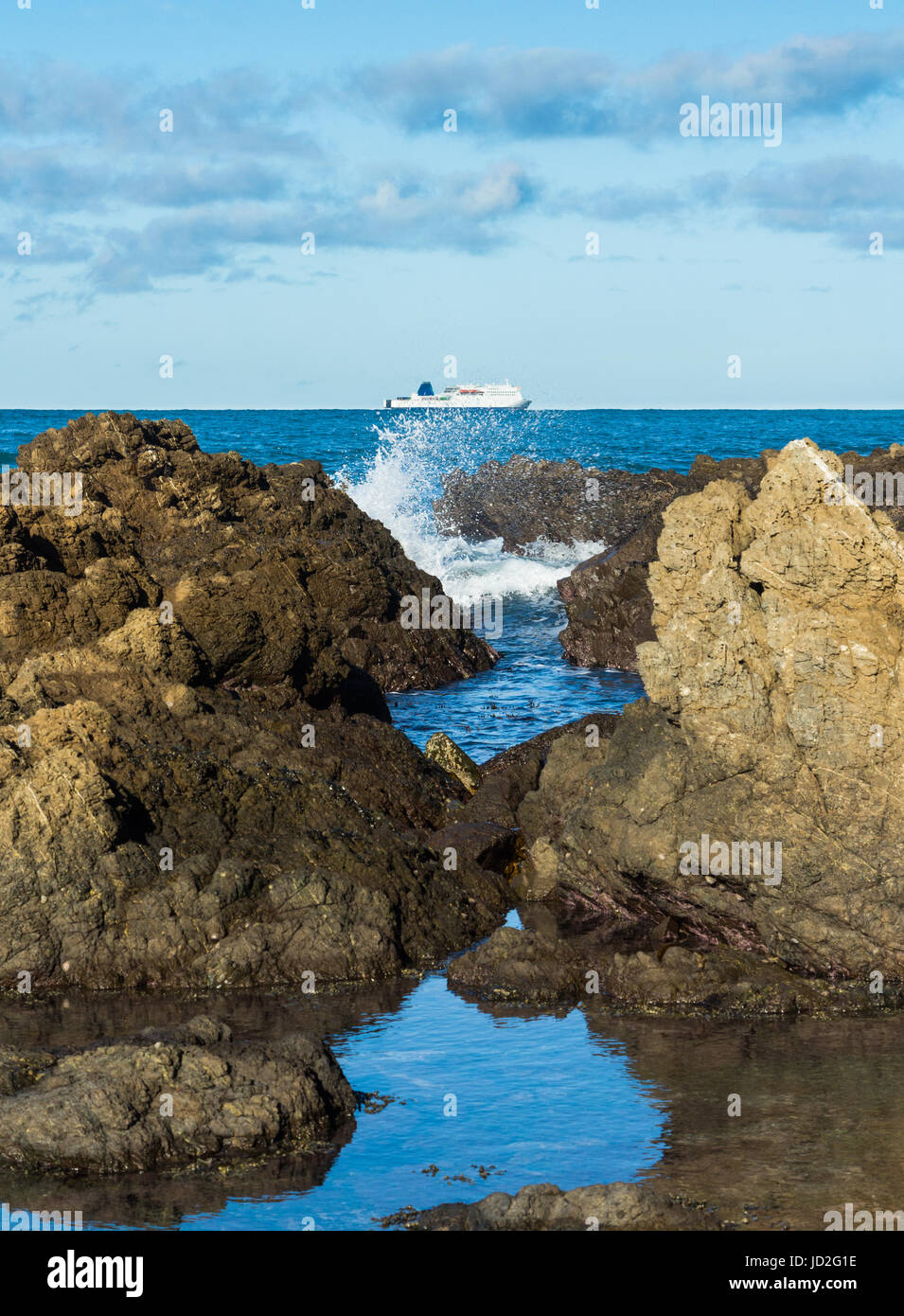 Rocky shoreline with a ship keeping away from the rocks Stock Photo - Alamy