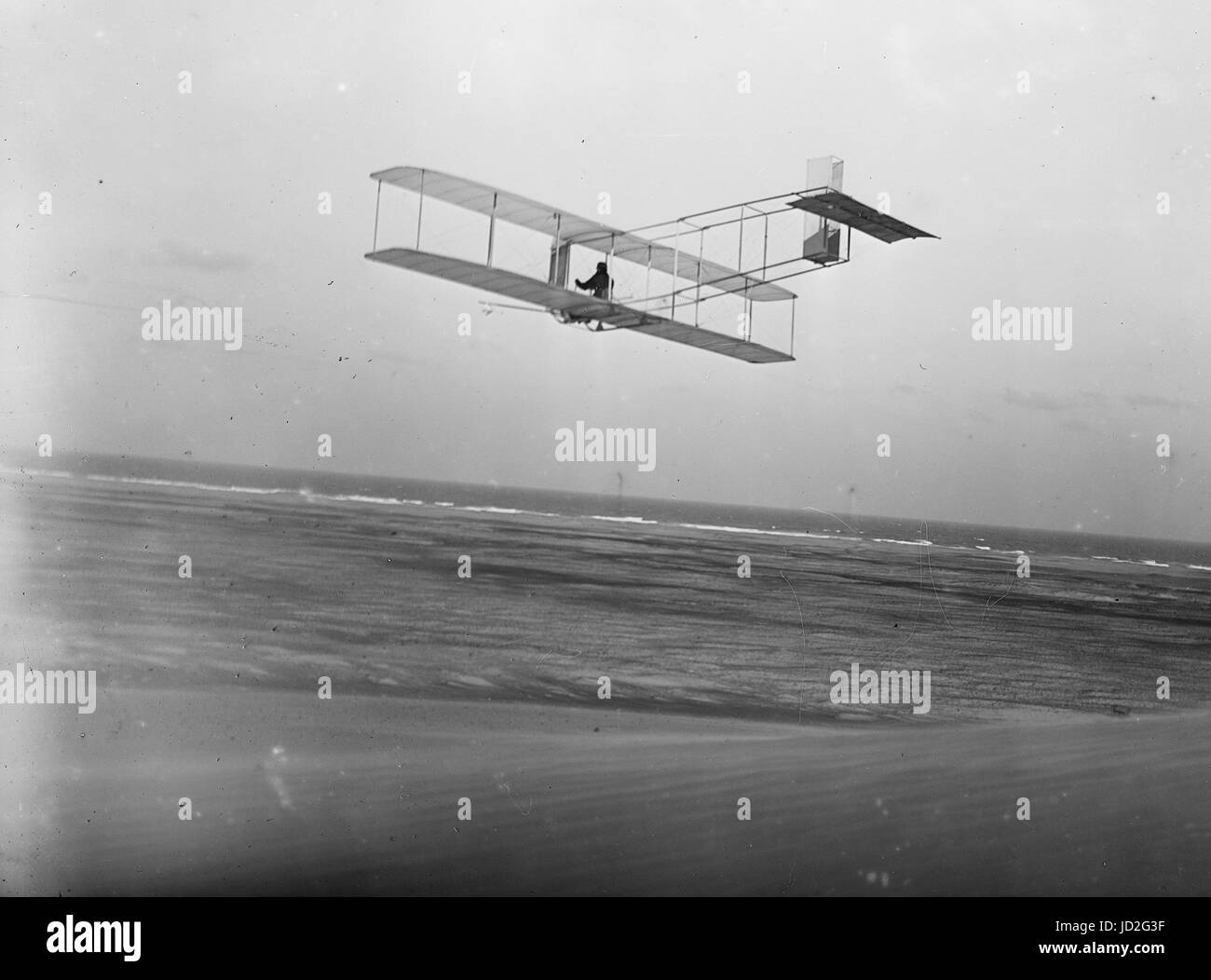 Three-quarter left rear view of glider in flight at Kitty Hawk, North ...