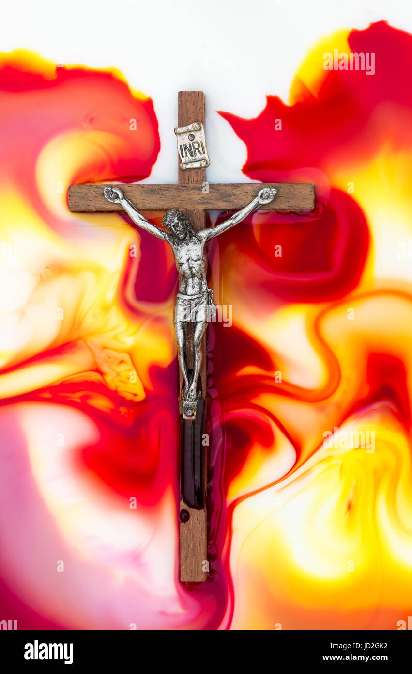 Metal crucifix on a wooden cross surround by blood red and orange ...