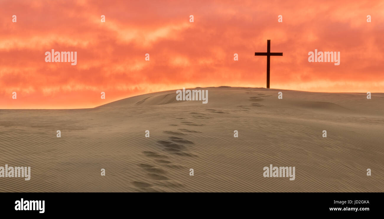 Black cross on a sand dune with foot steps leading up to it Stock Photo ...