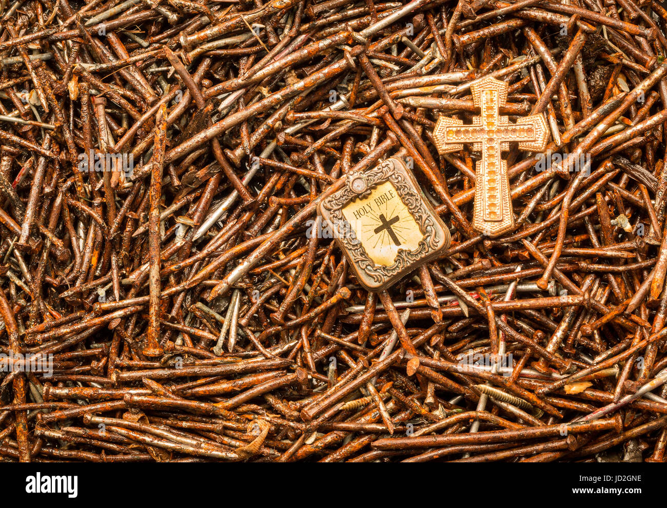 Golden cross and Bible on some used rusted old nails Stock Photo - Alamy