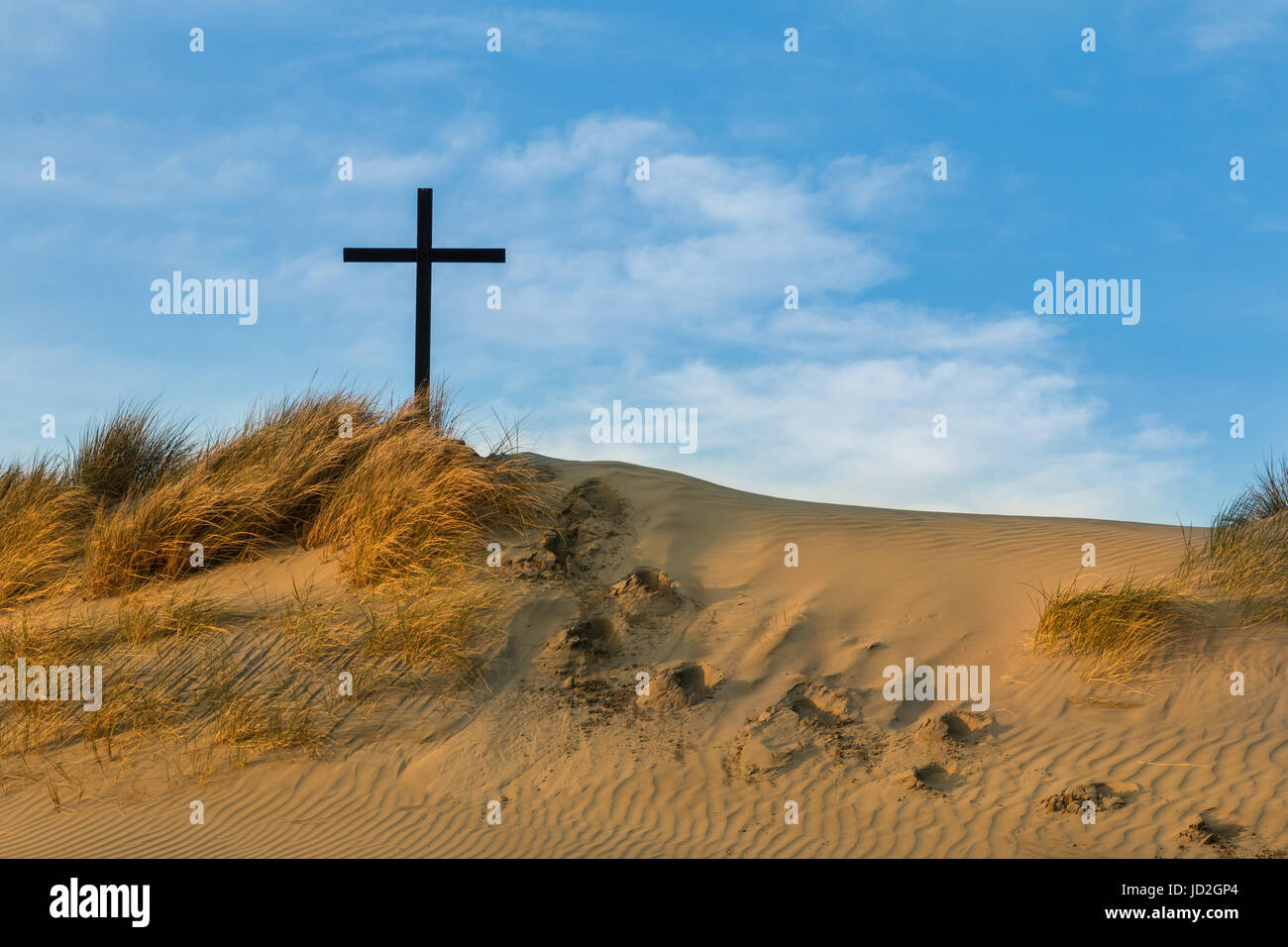 Black cross on a sand dune with foot steps leading up to it Stock Photo ...