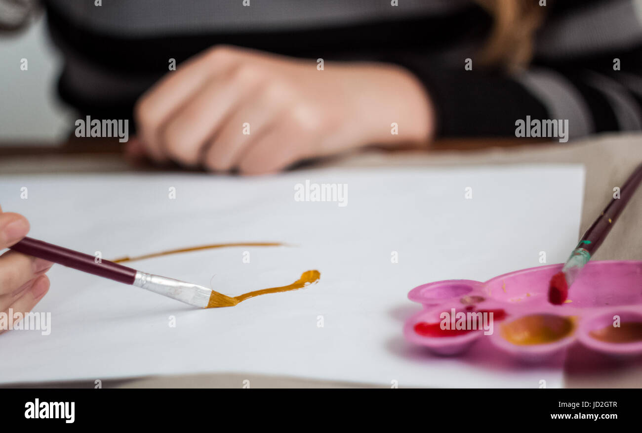 Girl painting with brush and colorful paint Stock Photo - Alamy