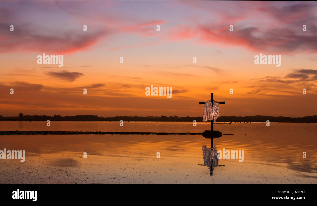 Shroud on a cross with a sunset sky at a lake Stock Photo - Alamy
