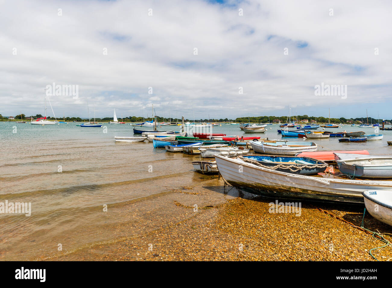 Rowing boats moored on the shoreline at West Itchenor, a small village ...
