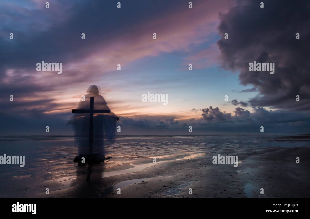 Cross with a faded image of Jesus with a clearing storm at a beach ...
