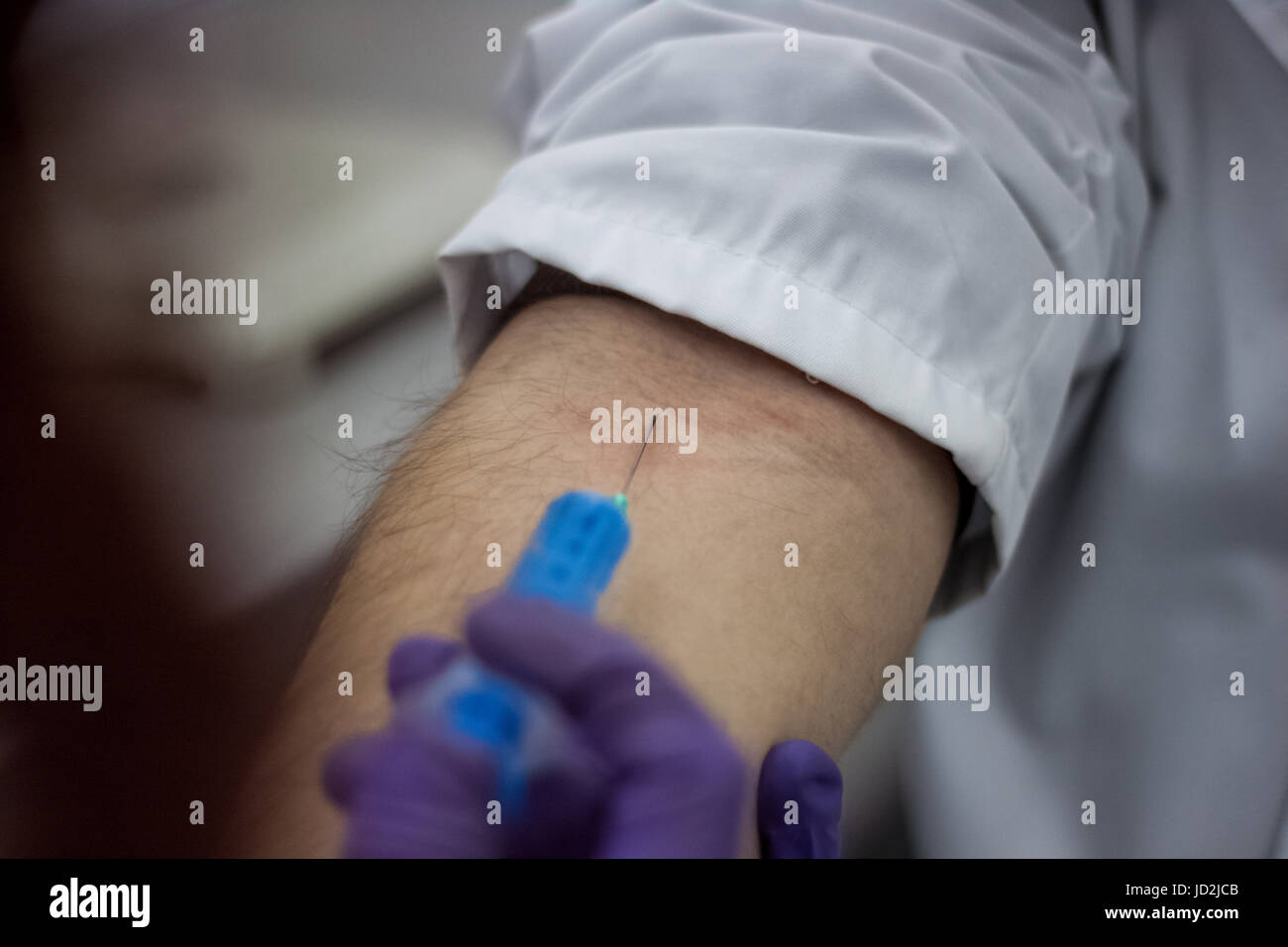 Doctor and patient sitting across from each other, while the doctor ...