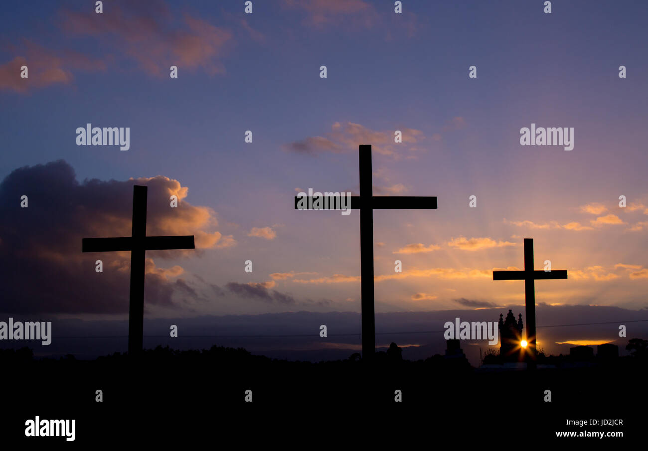 Dawn crosses with a bright sun rising through some clouds Stock Photo ...