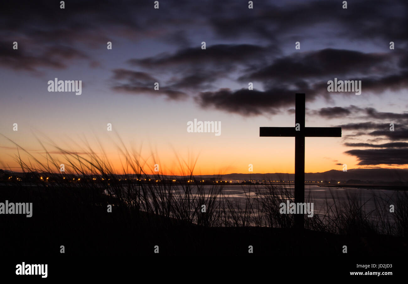 Cross on a hill over looking a river town at dawn Stock Photo - Alamy