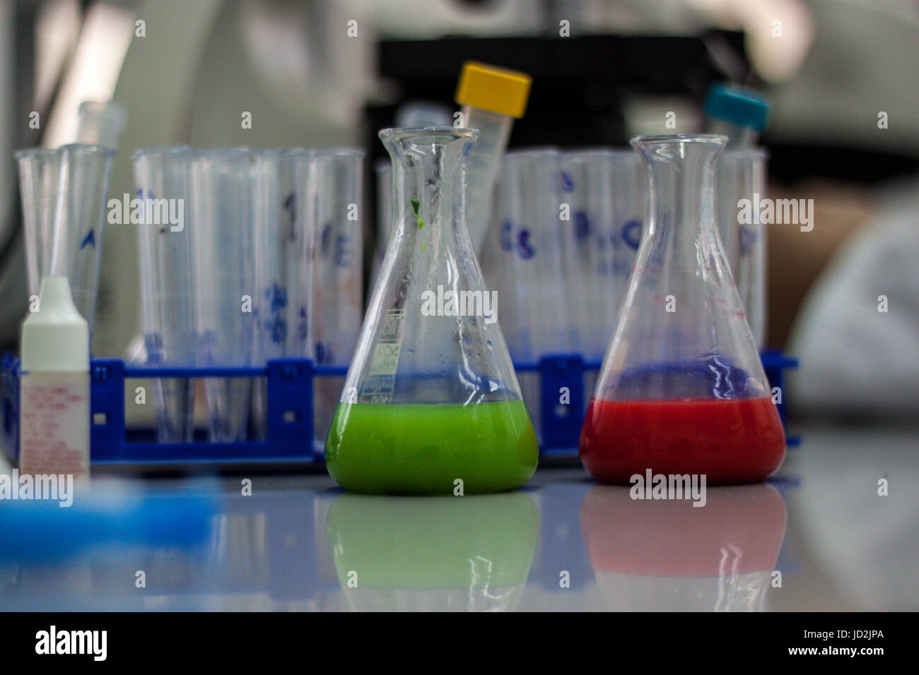 Green and red chemical compounds microscope and test tubes in ...