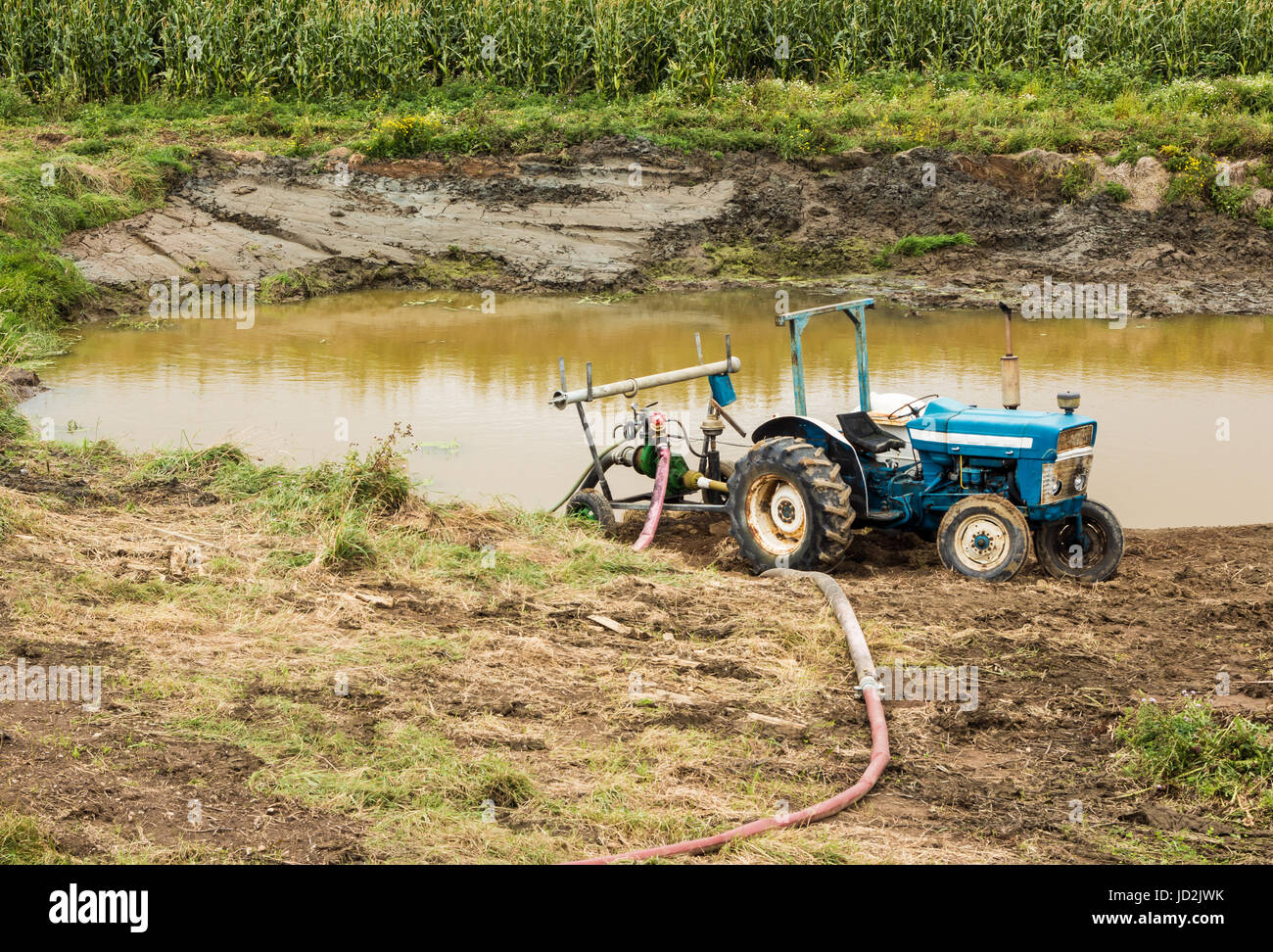 Tractor with a water pump on the back of it Stock Photo - Alamy