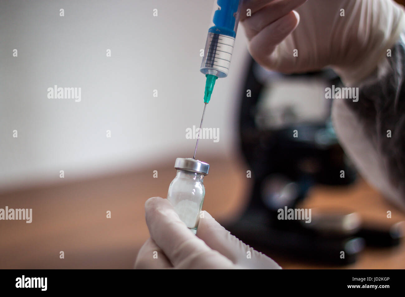 Young doctor prepares an injection to a patient, the injected liquid in ...