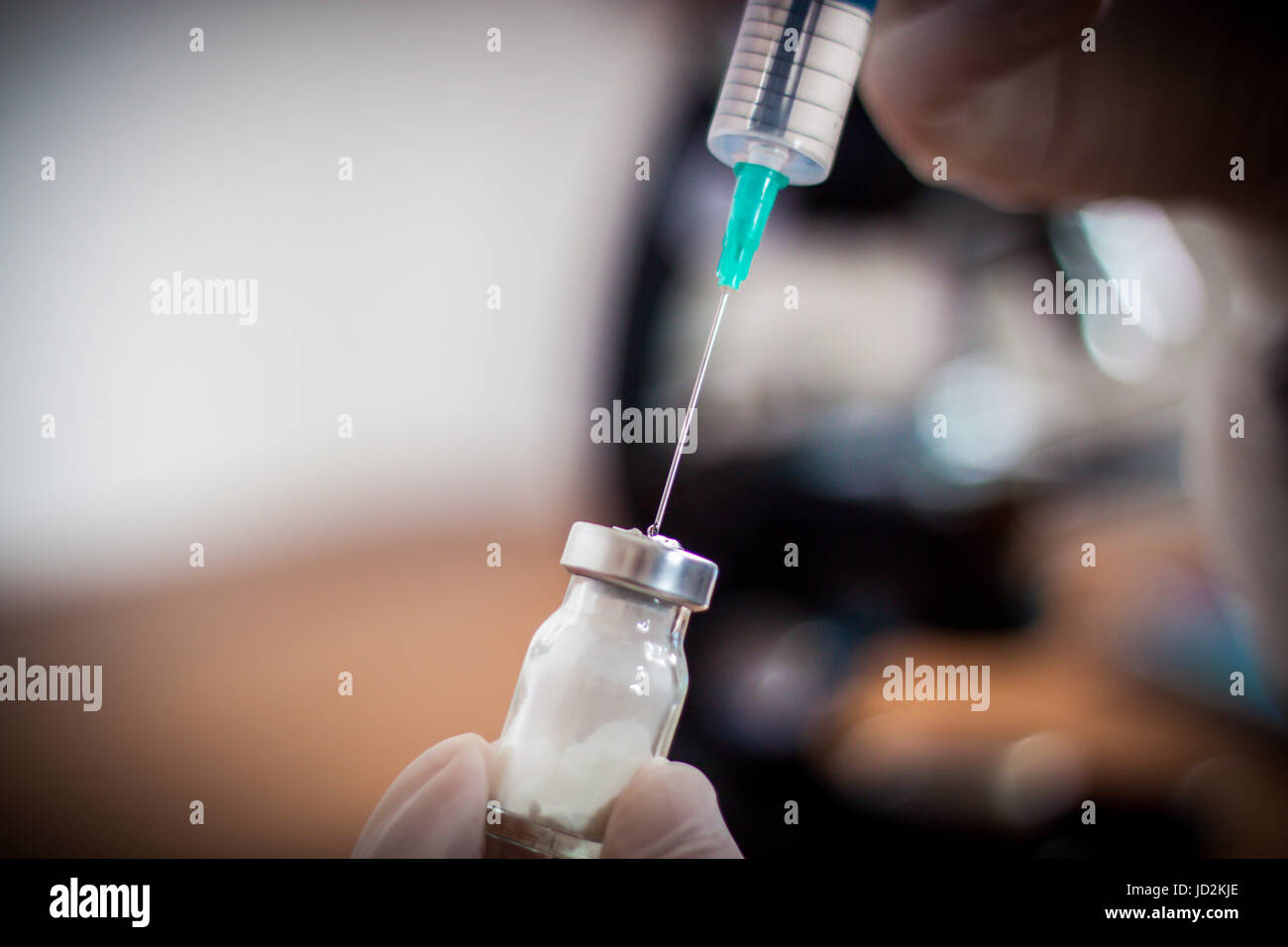 Young doctor prepares an injection to a patient, the injected liquid in ...