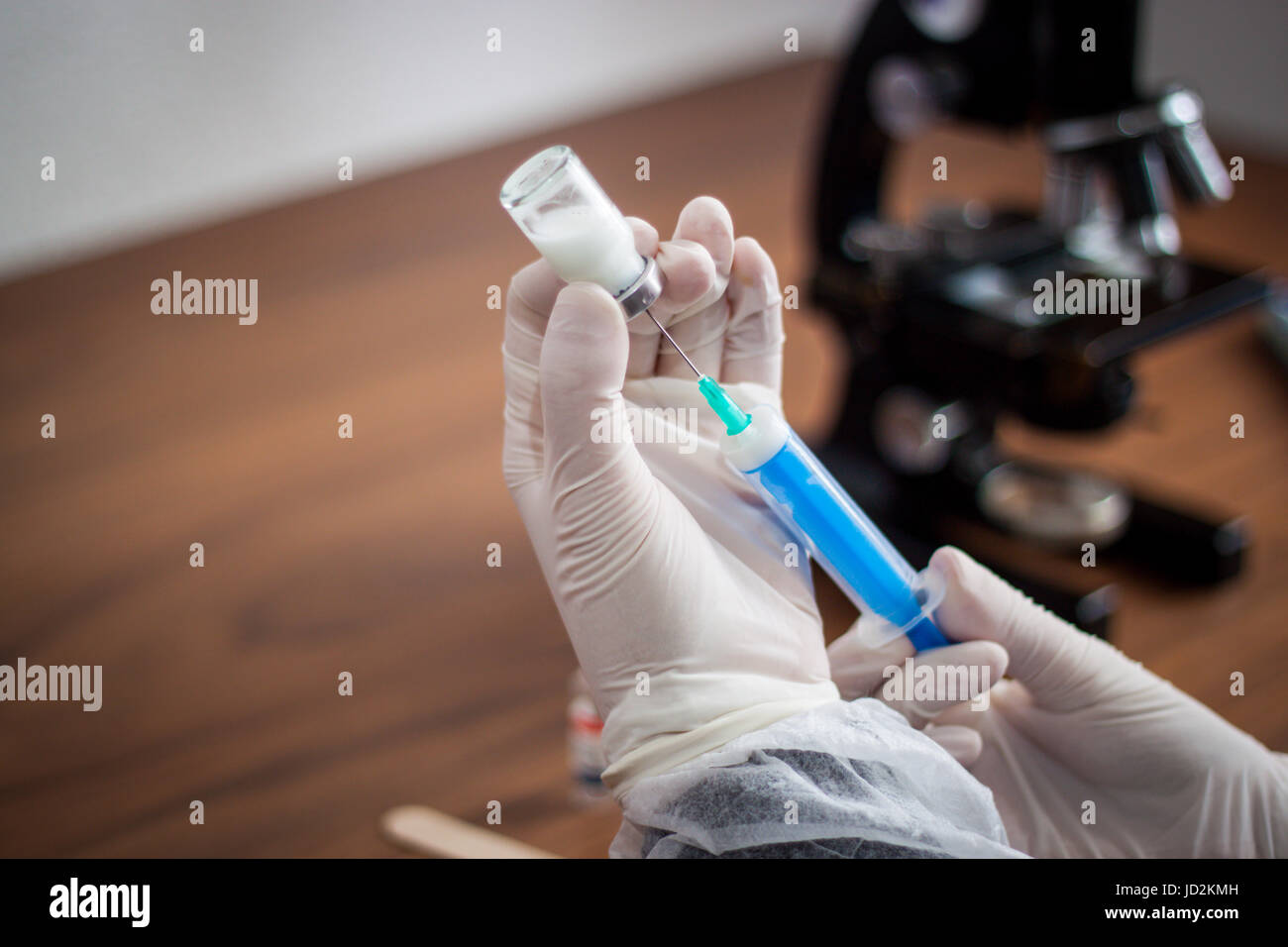 Young doctor prepares an injection to a patient, the injected liquid in ...