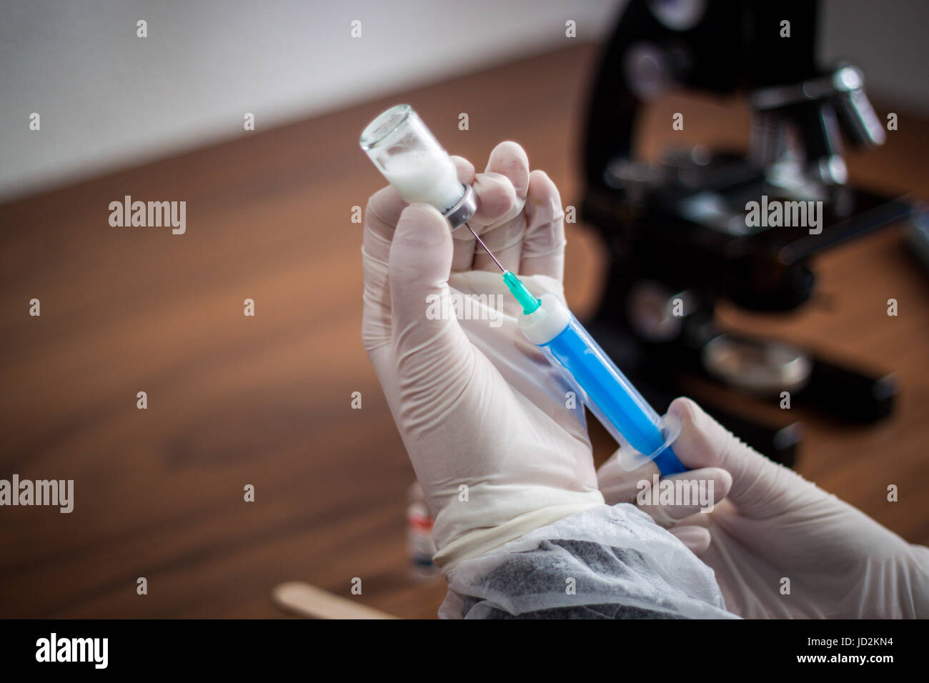 Young doctor prepares an injection to a patient, the injected liquid in ...