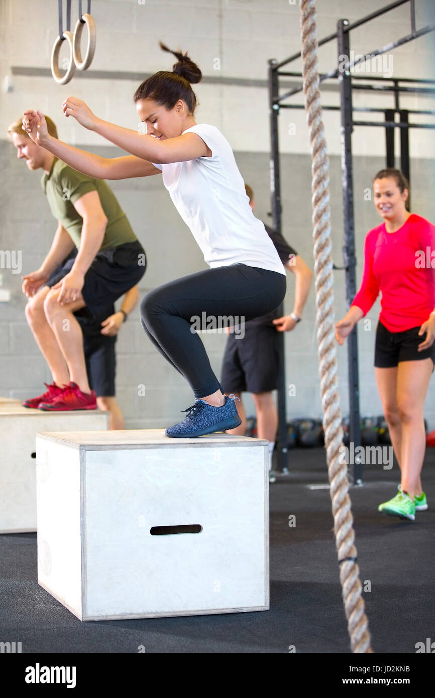 Determined Athletes Doing Box Jumping In Health Club Stock Photo - Alamy
