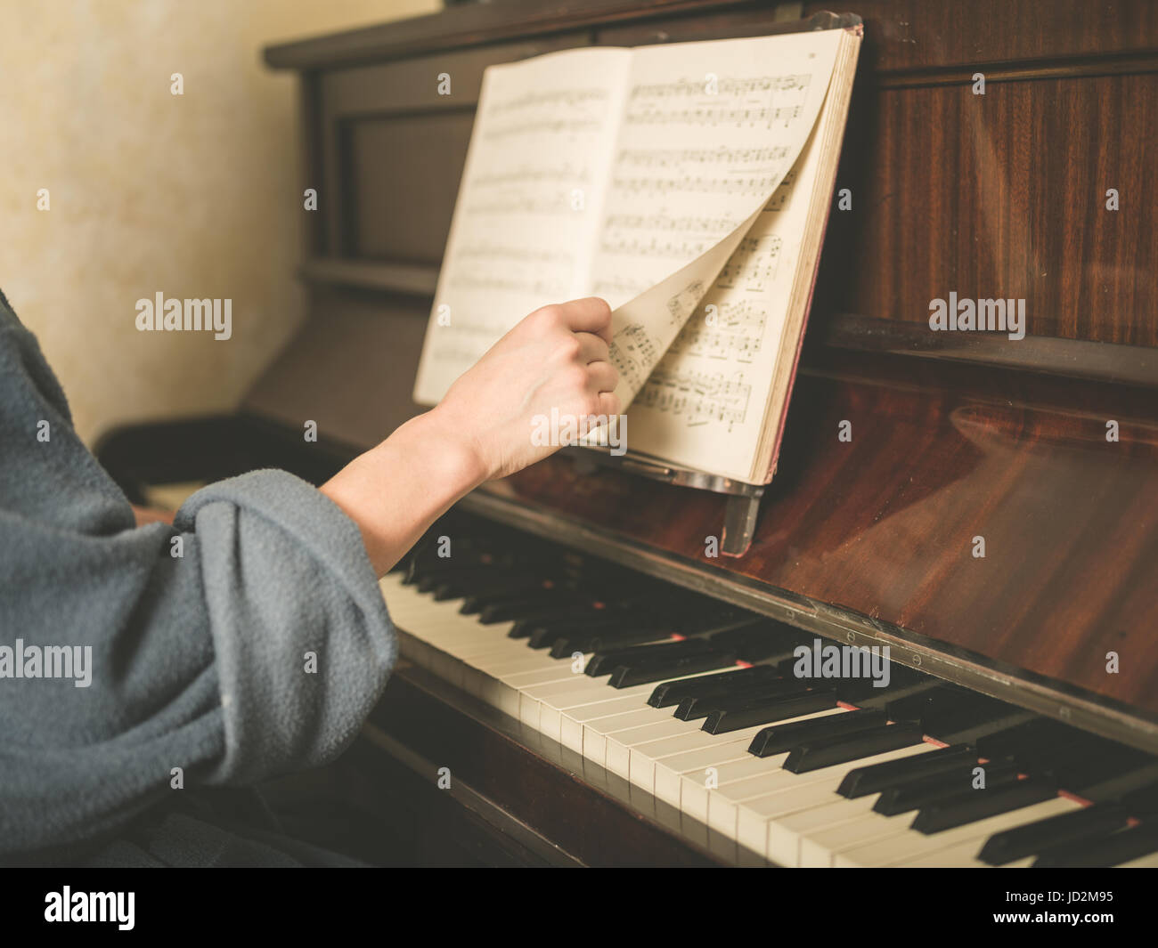 The hand of a young woman is turning music paper at a piano Stock Photo ...