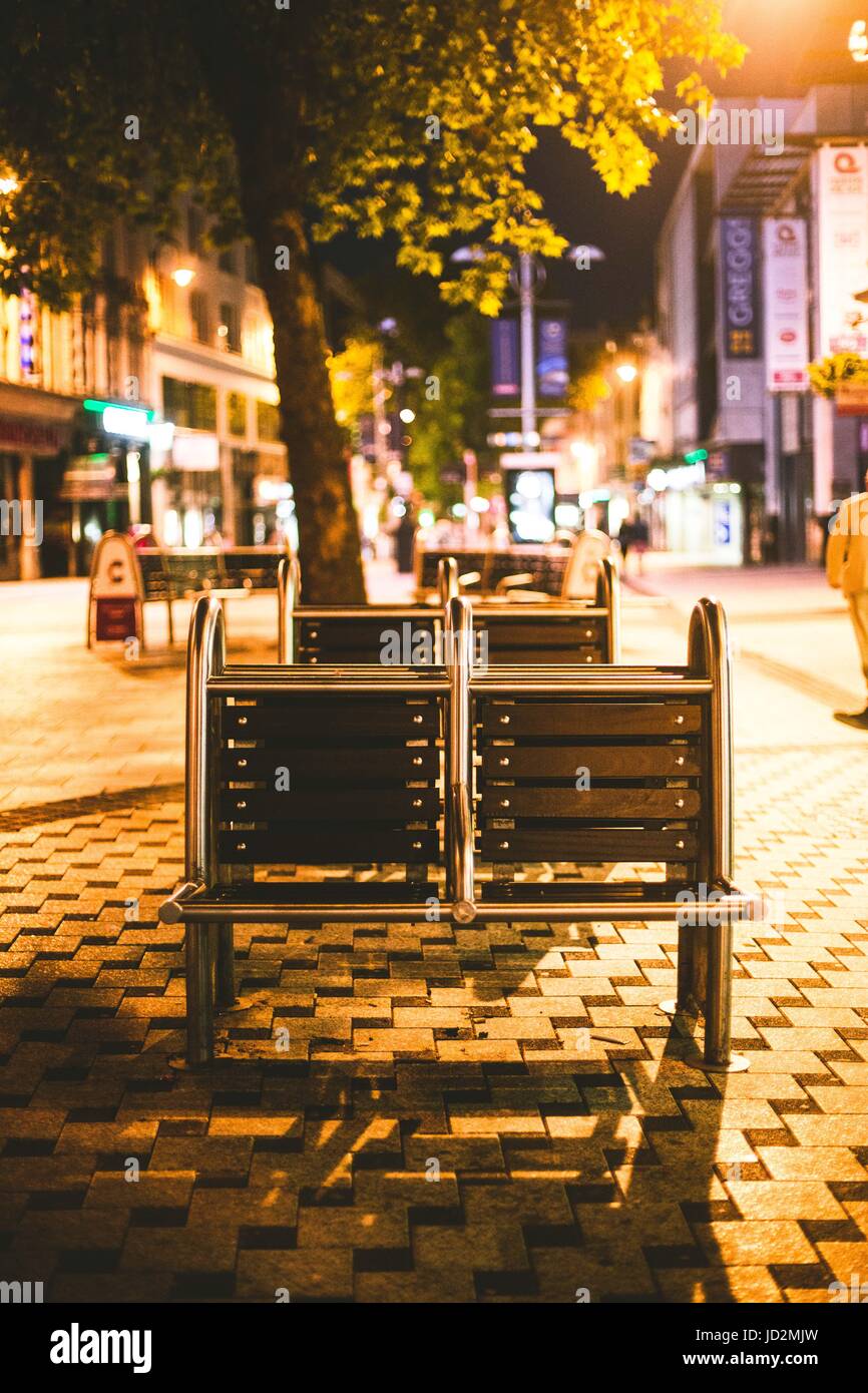 Photograph of a bench in the street at night Stock Photo - Alamy