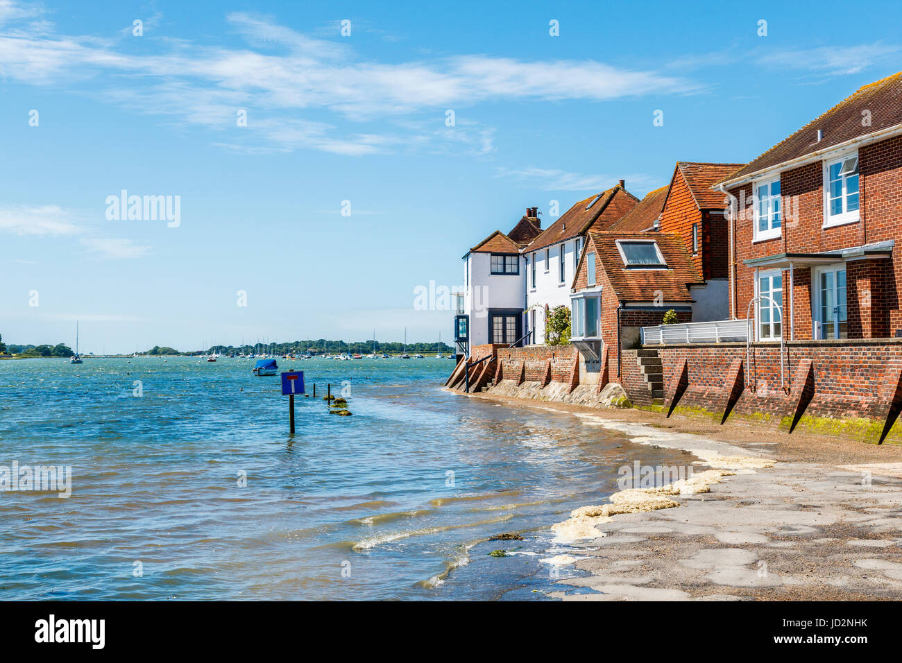 Rising tide flooding the seafront access road, Bosham, a south coast ...
