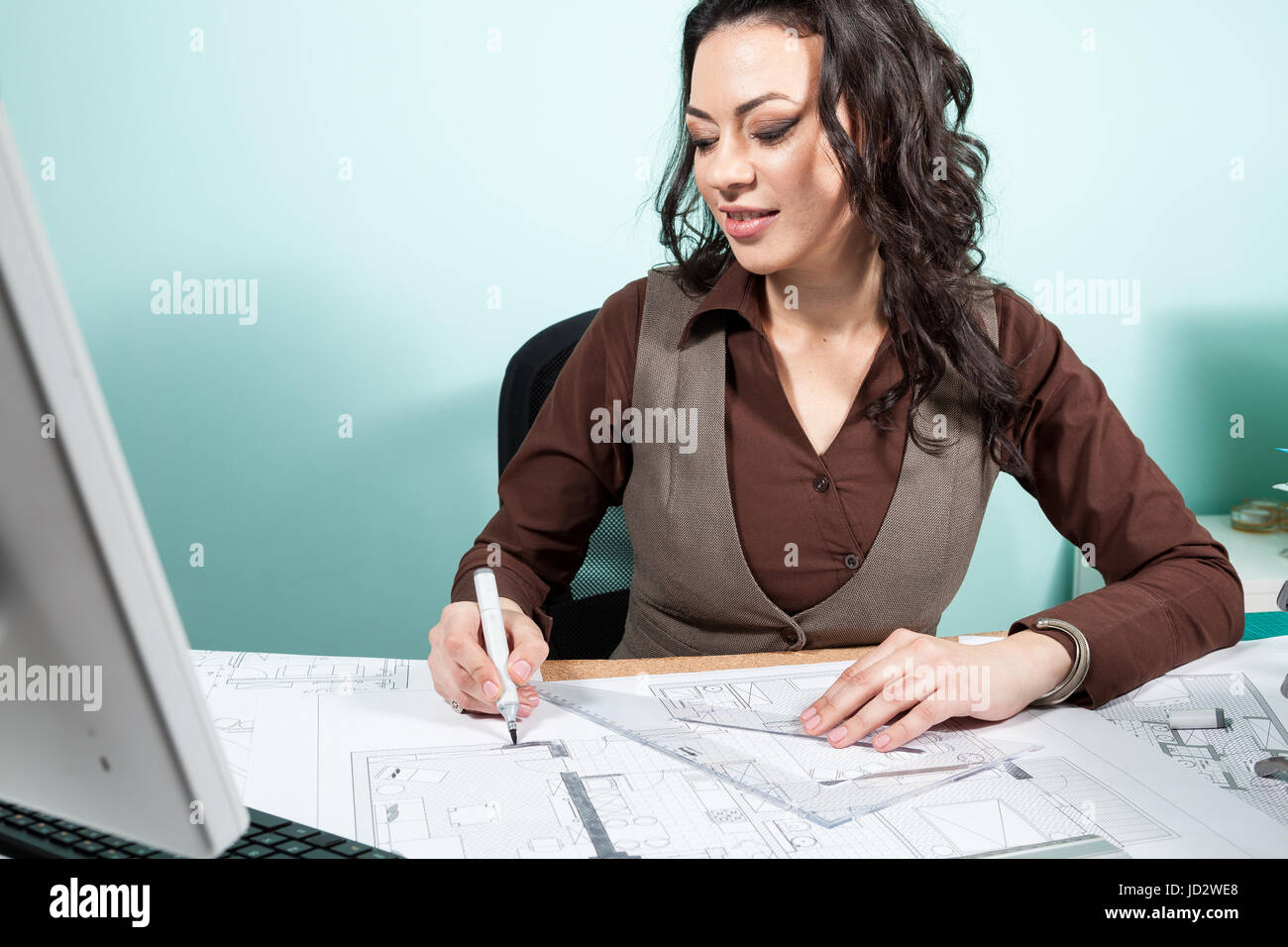 Woman at her office with blueprints in front of her Stock Photo - Alamy
