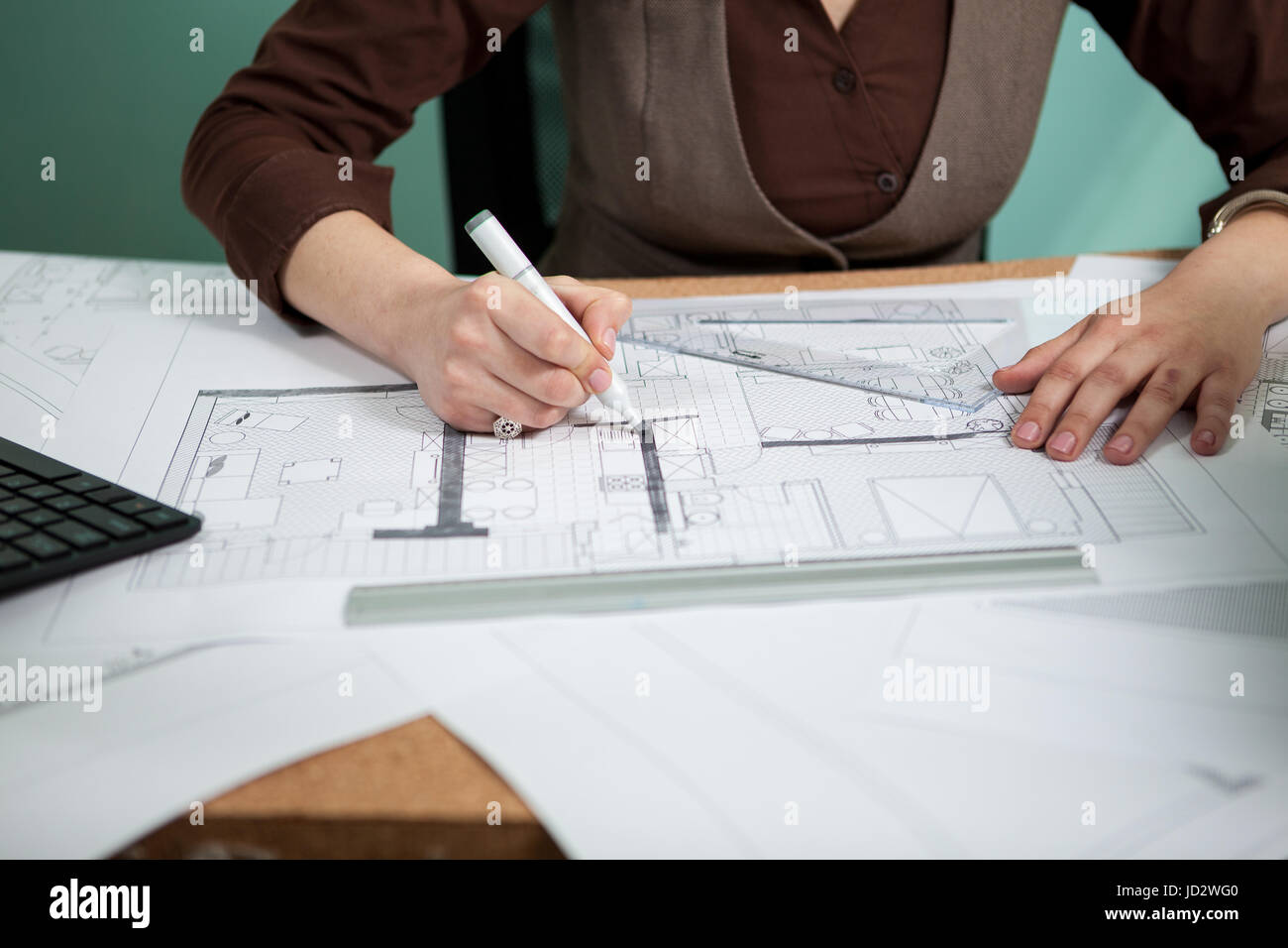 Architect working on blueprints on her desk Stock Photo - Alamy