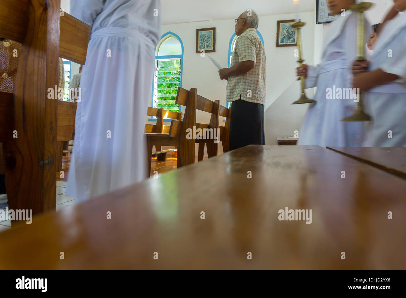 Low point of view indoors of Pacific Island man inside church holding ...