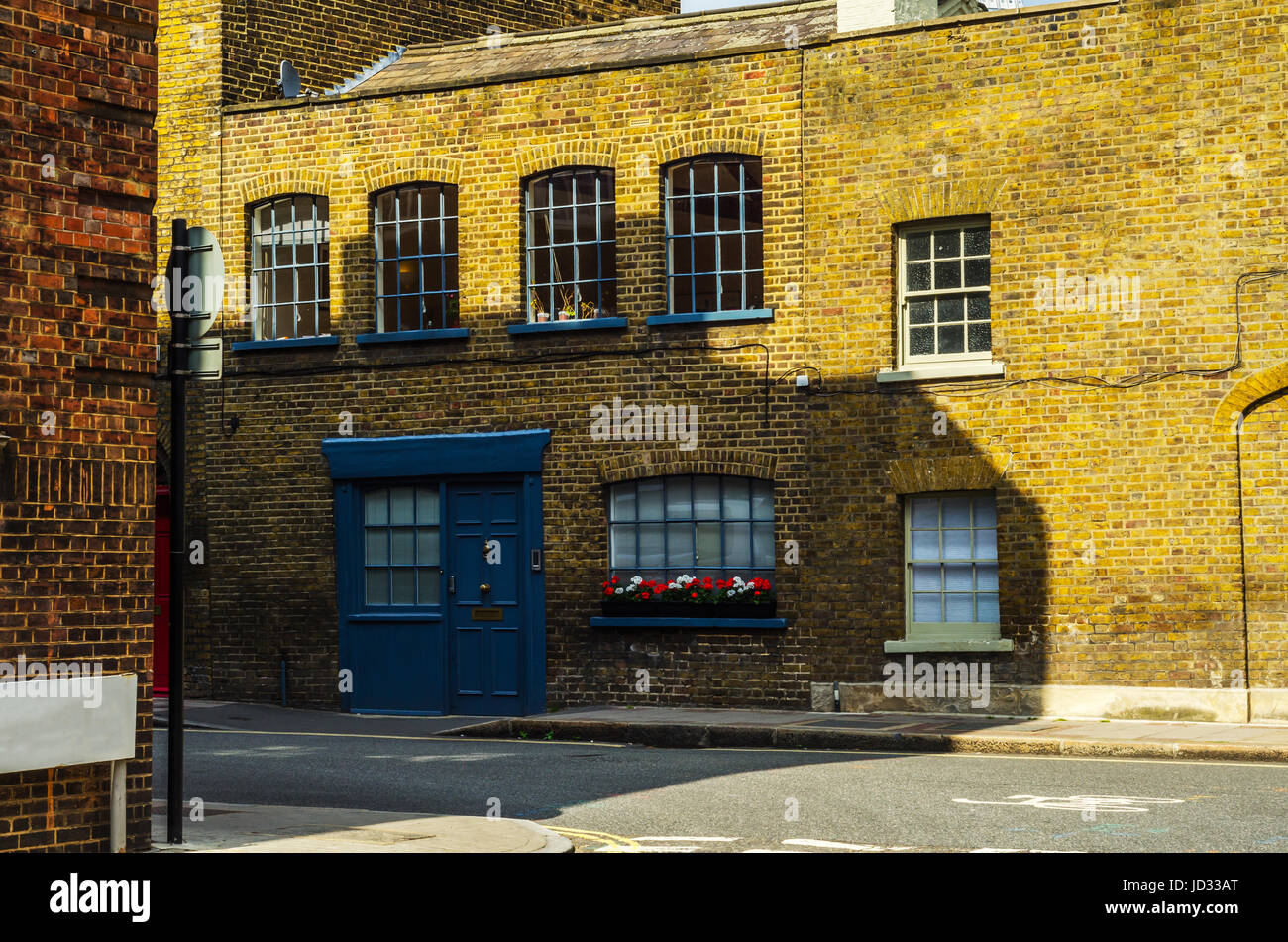 Typical old English buildings, low brick buildings across a narrow ...