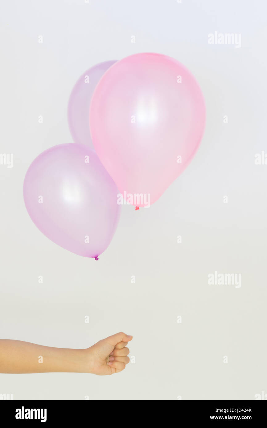 Womans hand holds balloons in a white background Stock Photo - Alamy