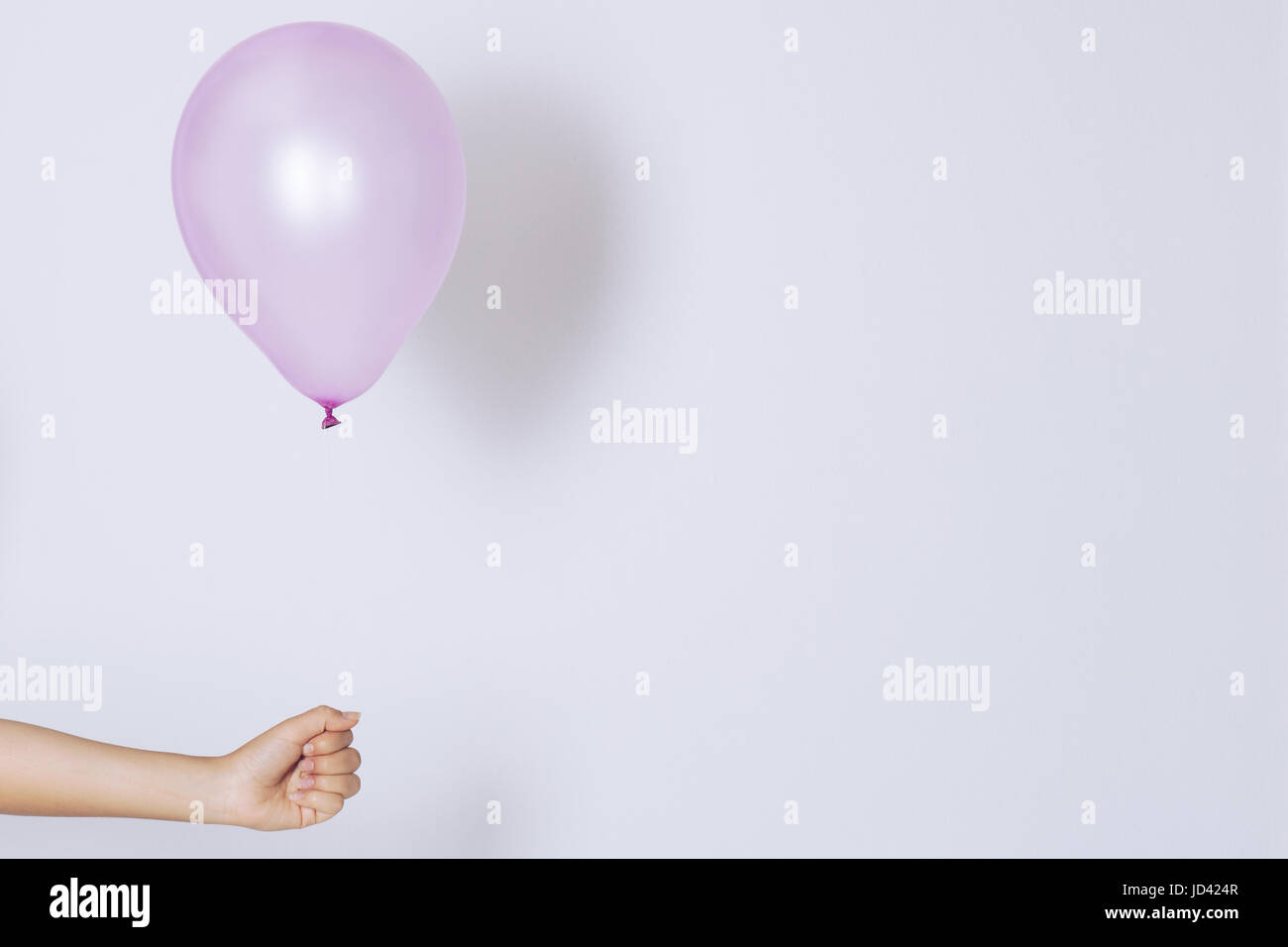 Womans hand holds balloons in a white background Stock Photo - Alamy