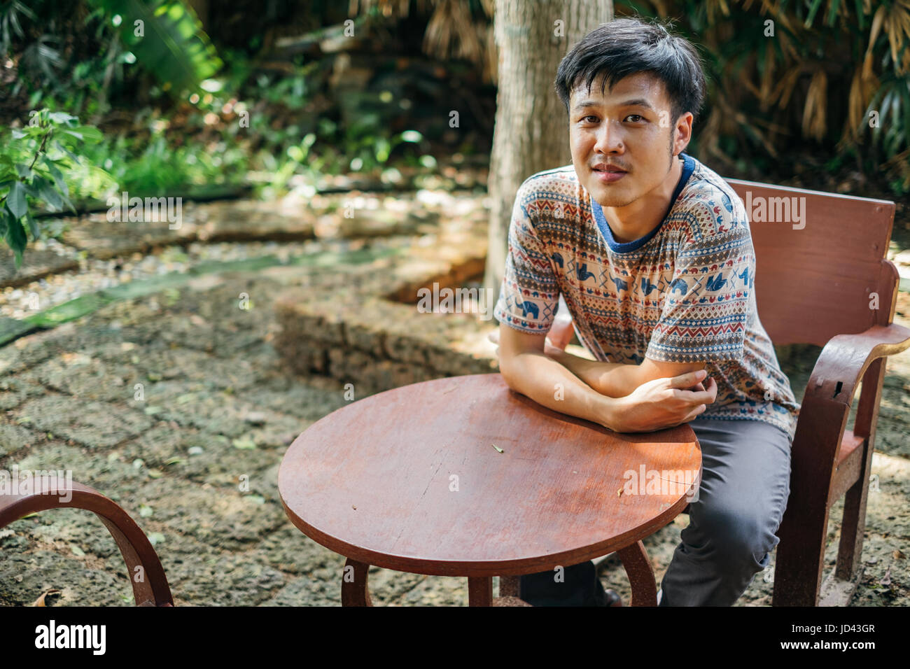 man sweating sitting on the wood chair at the garden Stock Photo - Alamy