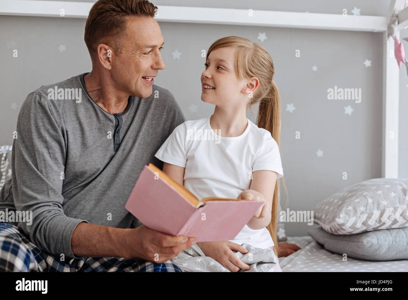 Curios bright girl asking her dad about the plot Stock Photo - Alamy