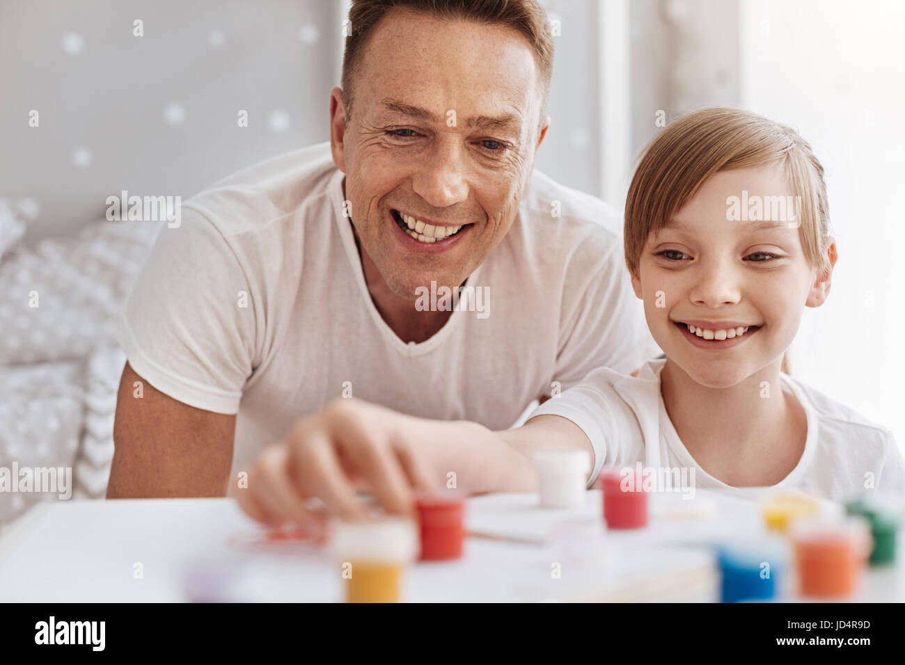 Lovely inspired parent learning about daughters hobbies Stock Photo - Alamy