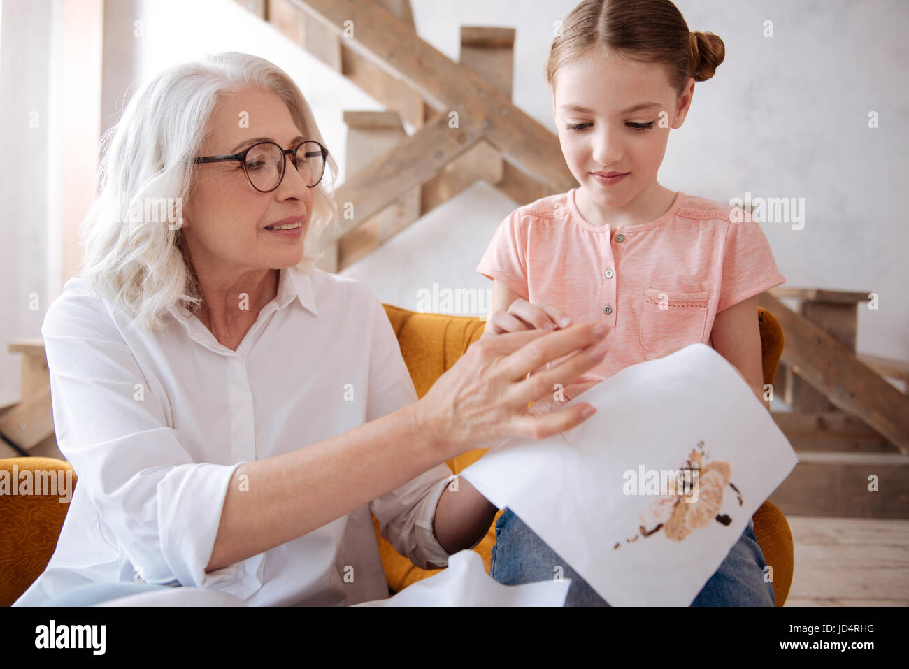 Nice pleasant woman helping her granddaughter Stock Photo - Alamy