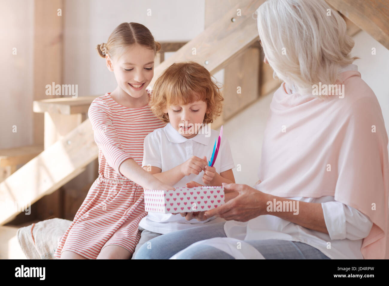 Curious happy children looking at their presents Stock Photo - Alamy