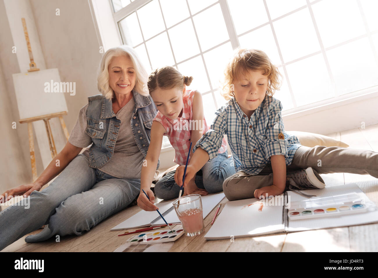 Serious creative children concentrating on painting Stock Photo - Alamy