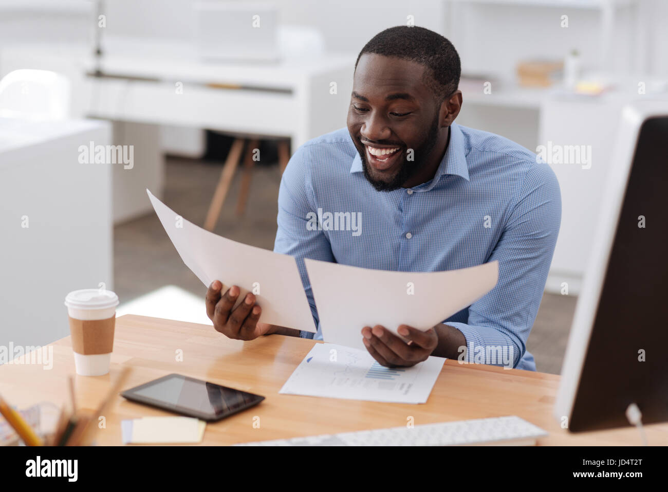 Happy emotional man reading documents Stock Photo - Alamy
